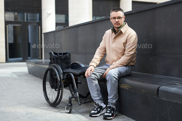 Man with disability sitting outdoors Stock Photo by AnnaStills | PhotoDune