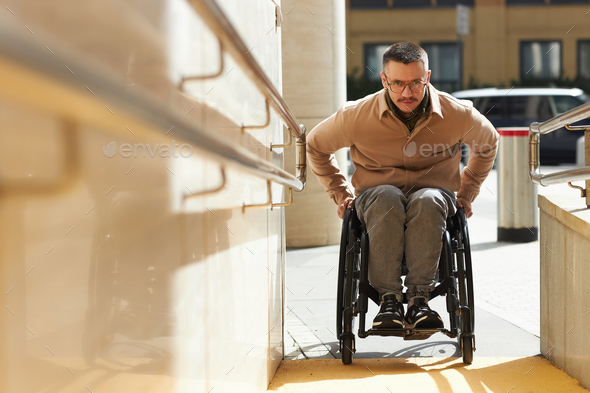 Man in wheelchair moving up the ramp Stock Photo by AnnaStills | PhotoDune