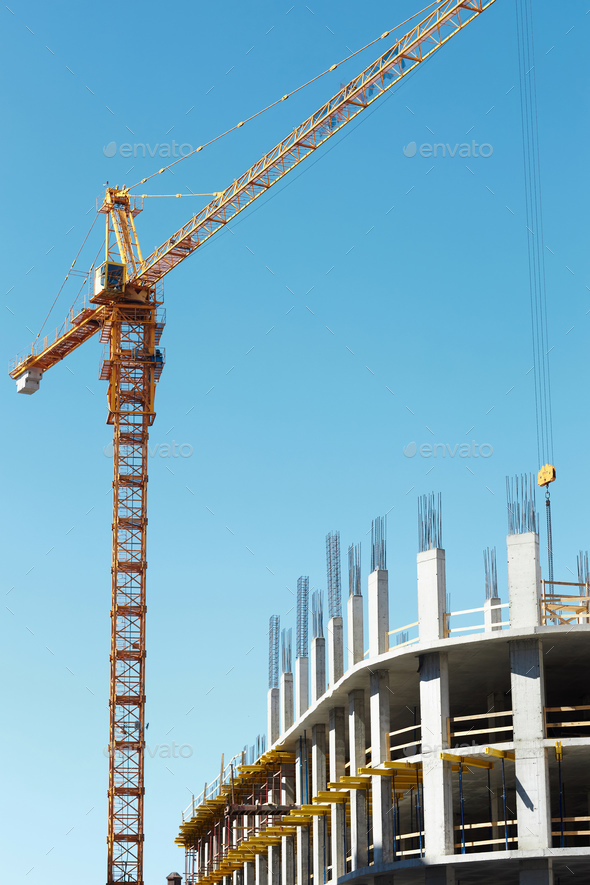 Construction crane builds a tall building Stock Photo by AnnaStills