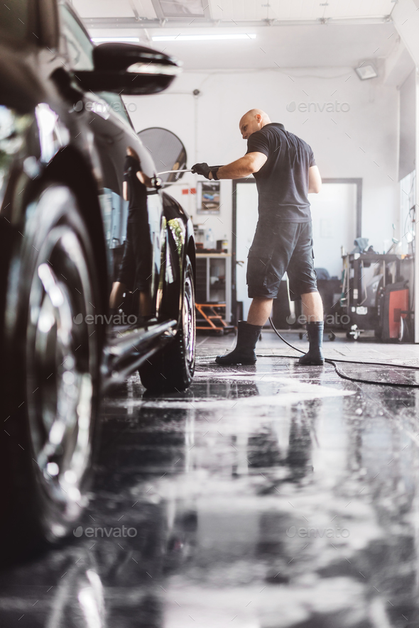 Service man washing car before detailing in workshop. Stock Photo by ...