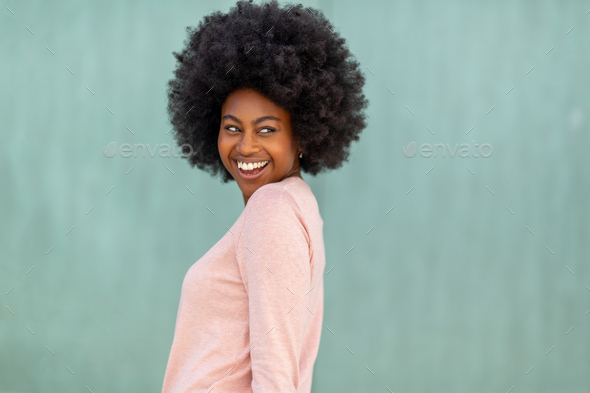 Happy young black woman glancing back Stock Photo by mimagephotography