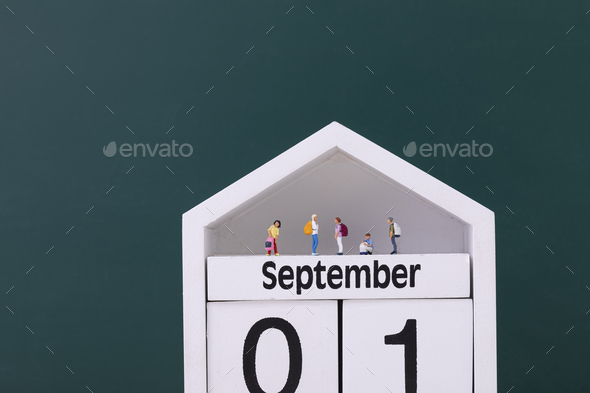 Student figurines standing on calendar depicting the first of September ...