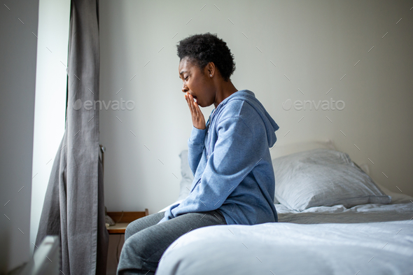 Profile of young african American woman waking up in bed and yawning ...
