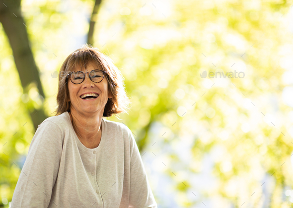 carefree older woman with glasses laughing outdoors Stock Photo by ...