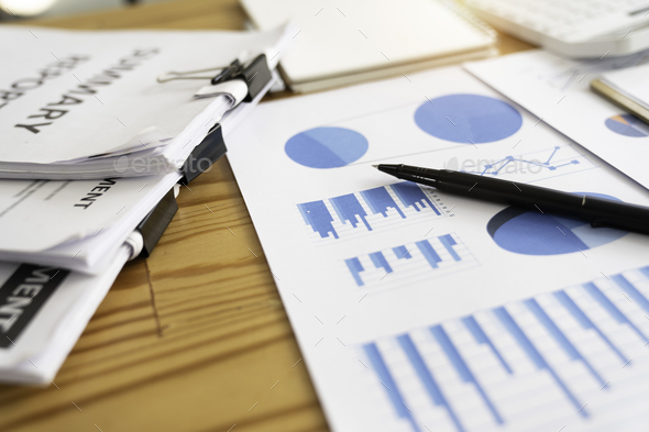 Paper report. Blue graphs and charts. Business reports and a pile of ...