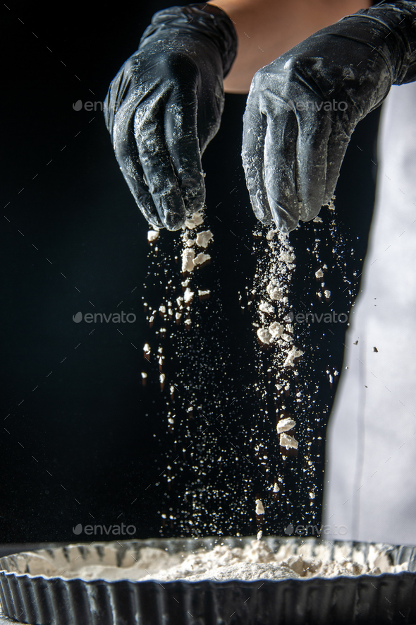 front view female cook pouring white flour into the pan with her palms ...