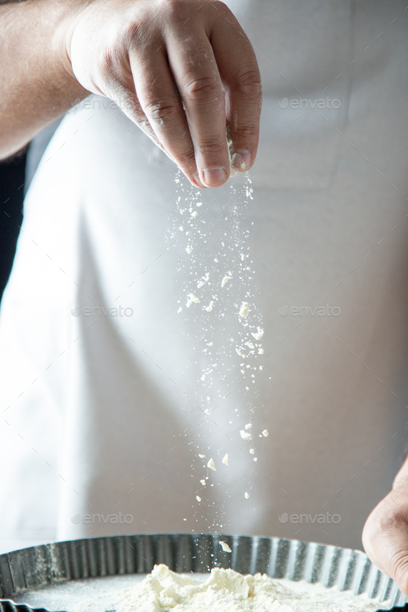 Half body shot of male chef wearing his uniform preparing pastry with ...