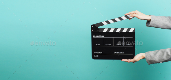Black Clapper board with hands in grey suit on green Tiffany Blue ...