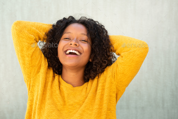 Close up carefree young African American woman laughing with hands ...