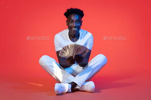 Rich black guy holding cash dollar banknotes Stock Photo by Prostock-studio