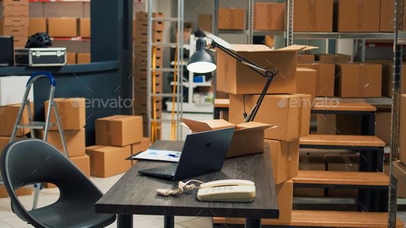 Empty desk room in storage warehouse area filled with carton boxes ...