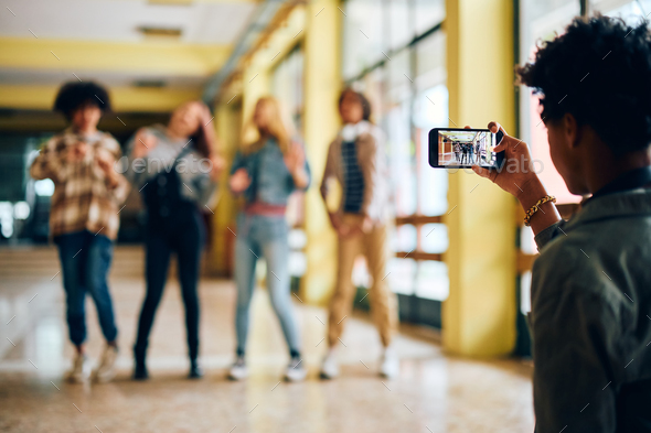 Close up of high school student taking picture of his classmates with ...