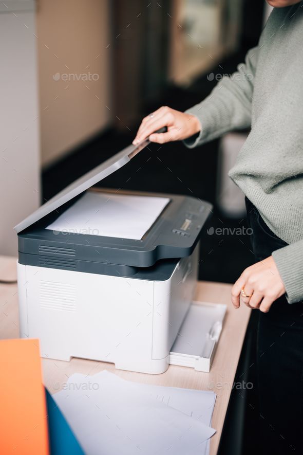 Female office worker using the printer at the office Stock Photo by ...
