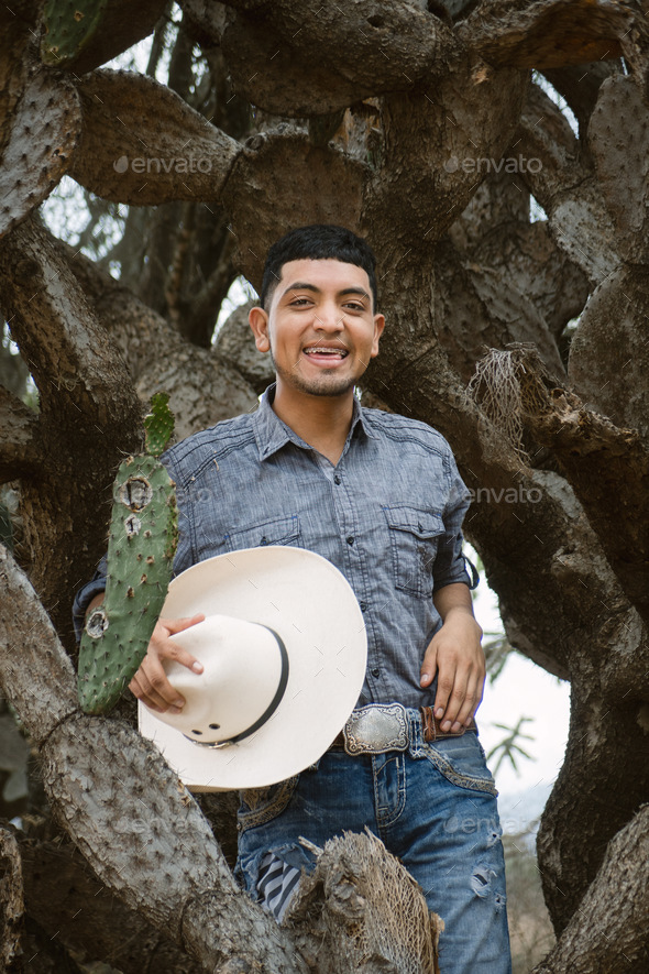 Smiling cowboy wearing a hat and sunglasses, enjoying outdoor ...