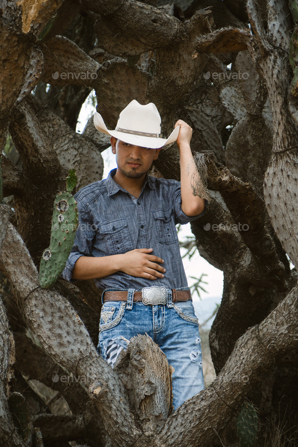 Smiling cowboy wearing a hat and sunglasses, enjoying outdoor ...