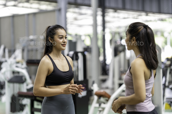Female fitness instructor showing exercise progress to a young athletic ...