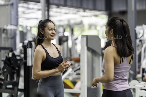 Female fitness instructor showing exercise progress to a young athletic ...