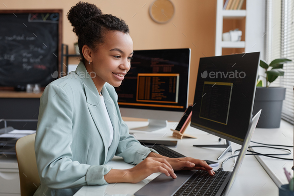 Side view portrait of young black woman programming code Stock Photo by ...