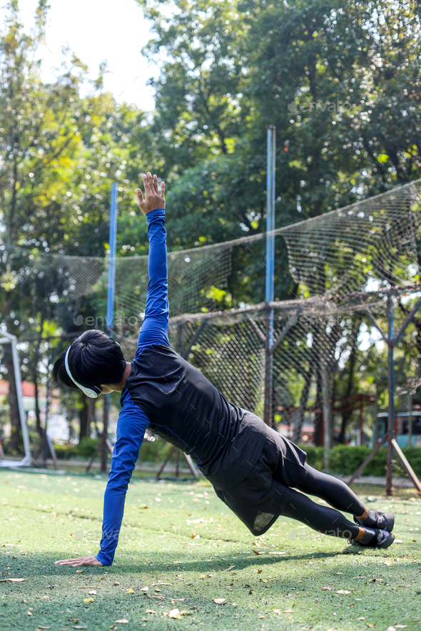 Full body back view young sporty man in sport suit doing side plank ...