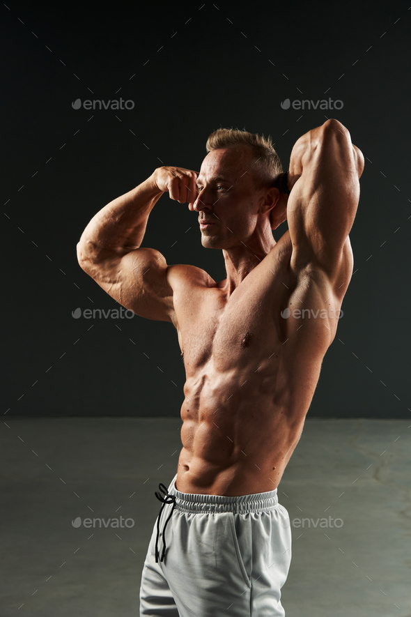 The Caucasian man raised one arm up behind his head, and bent the other ...