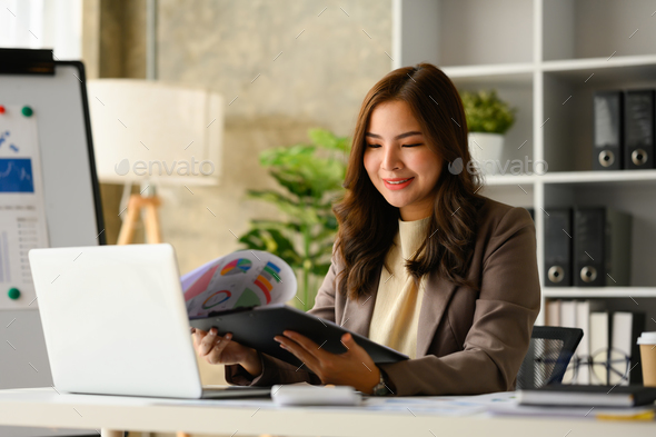 Gorgeous female entrepreneur in luxury suit working on sale marketing ...