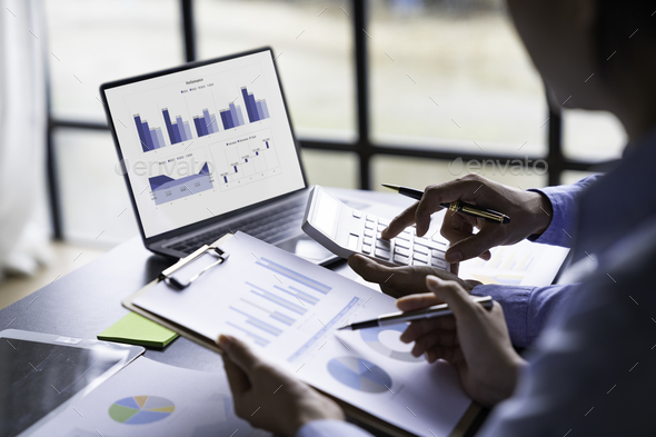 Business and partnership discussing using calculator to review balance ...