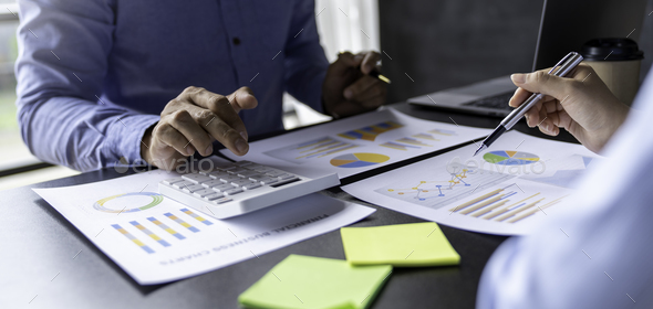 Business and partnership discussing using calculator to review balance ...