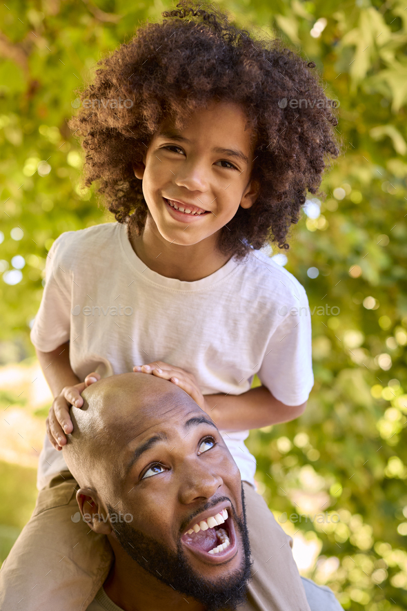 Father And Son In Summer Garden With Boy Riding On Dads Shoulders Stock ...