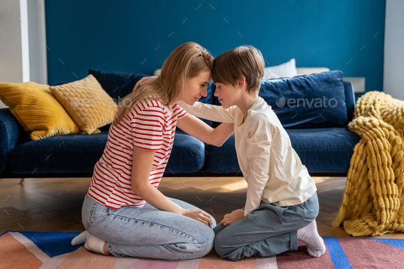 Mother and son touching foreheads while spending time together at home ...