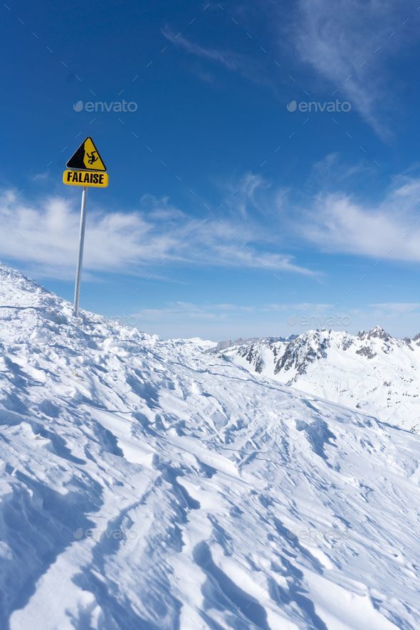 Vertical shot of a yellow and black warning sign against a backdrop of ...