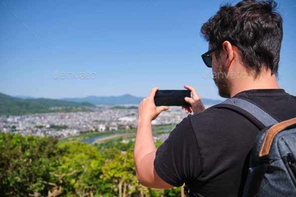 Tourist taking a photo of Kyoto city view from Arashiyama Monkey Park Iwatayama. Stock Photo by ...