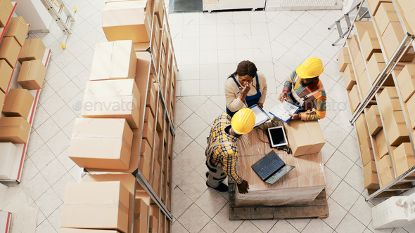 Warehouse employees packing goods in containers Stock Photo by DC_Studio