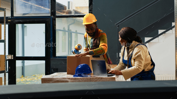 Team of workers using racks and shelves to stack boxes Stock Photo by ...