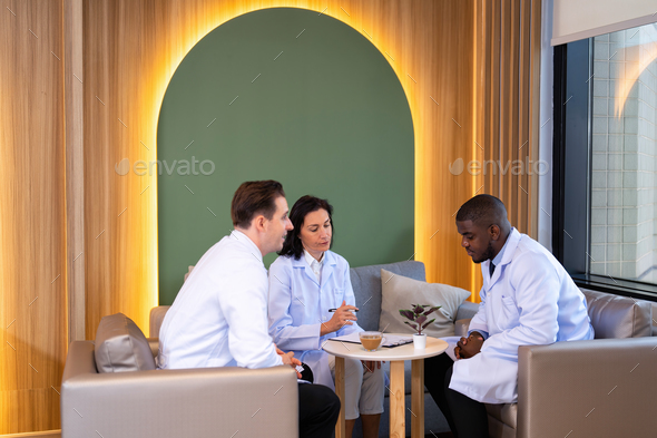 Healthcare doctors sitting on sofa in pantry room at modern hospital ...