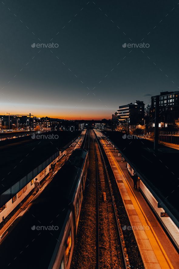 Night scene featuring a train passing through a bustling city ...