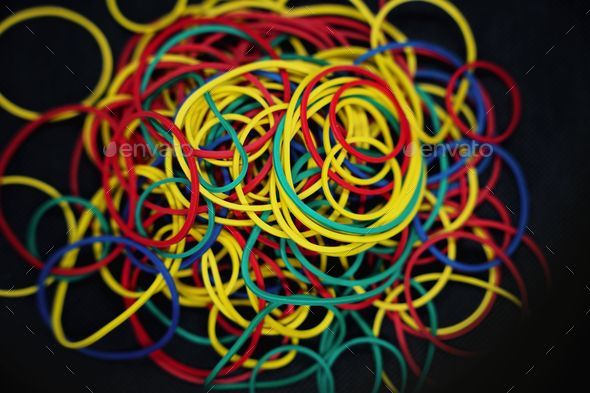 Close up of different colored rubber bands isolated on a black ...