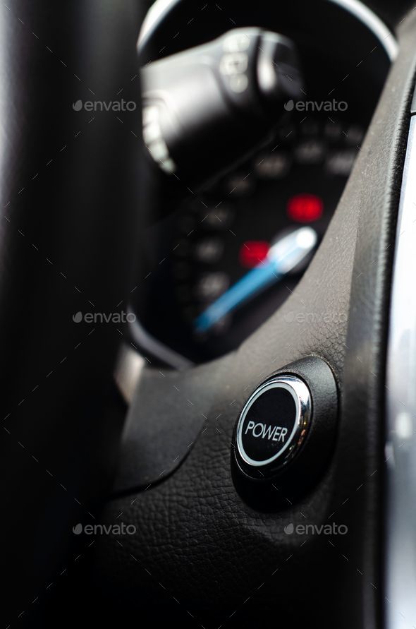 Start stop engine button on a modern car dashboard Stock Photo by wirestock