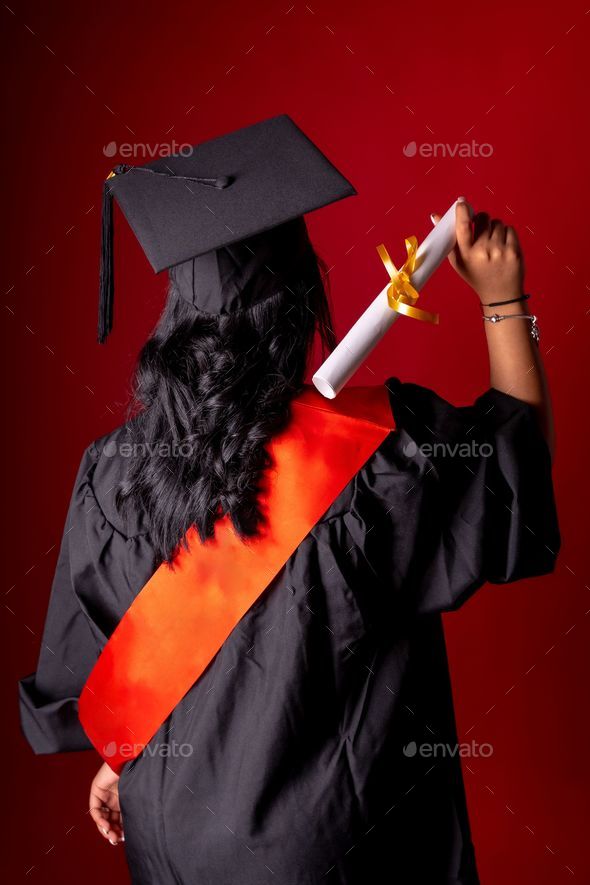 Young female graduate standing proudly in her academic regalia with her ...