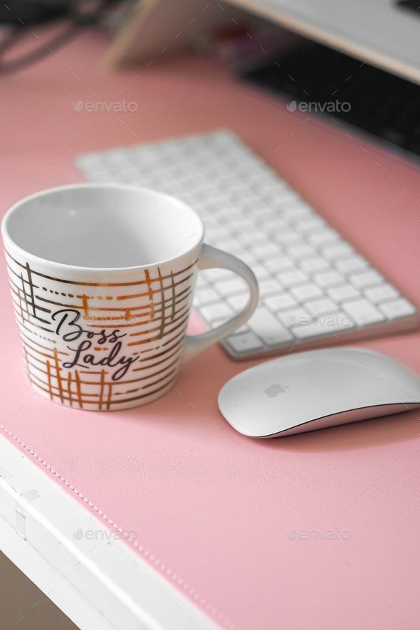 White ceramic mug resting on a desktop computer desk next to a computer ...