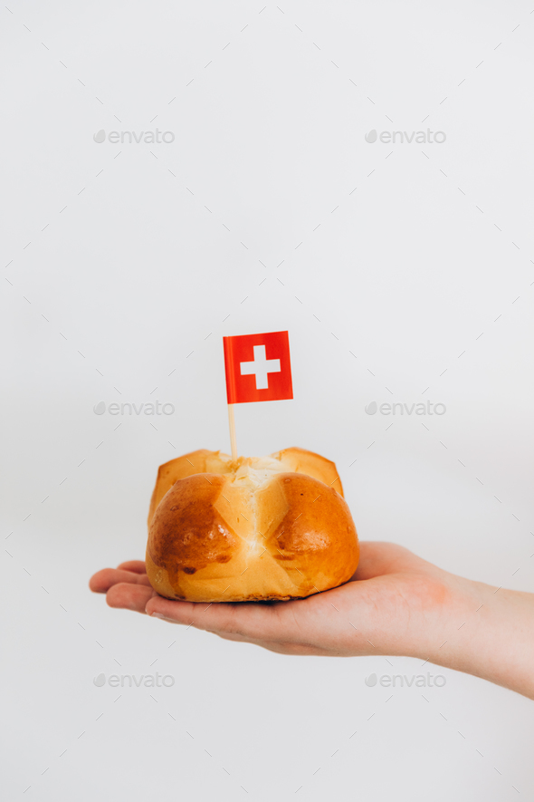 Bread bun with swiss flag in child hand. National holiday in ...
