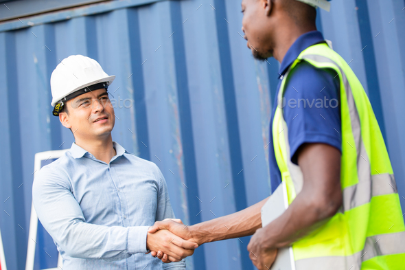 Engineer foreman handshaking with African American construction site ...