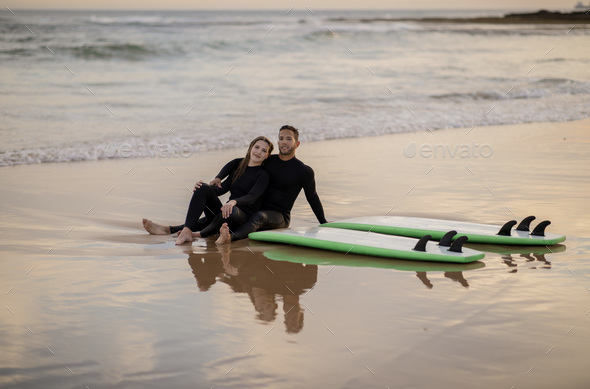 Surf Date. Young Beautiful Couple Relaxing On The Beach After Surfing ...