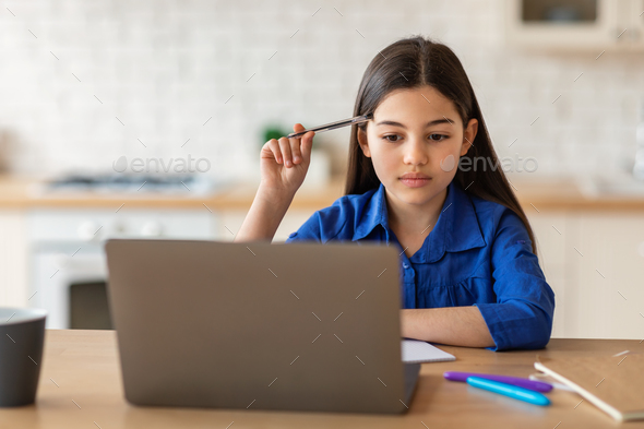 Pensive School Girl Studying With Laptop At Home Holding Pen Stock ...