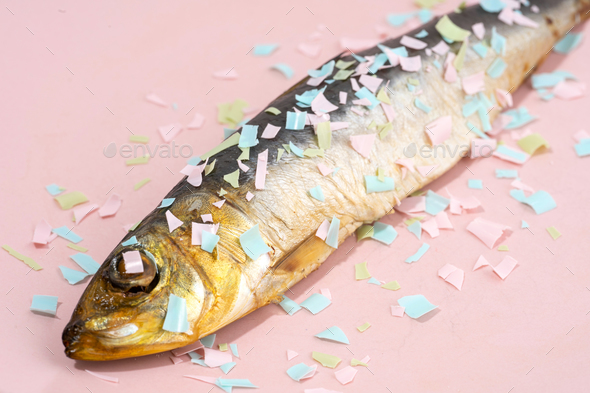 Fish covered microplastic on a pink plate. Impact of micro plastic on ...