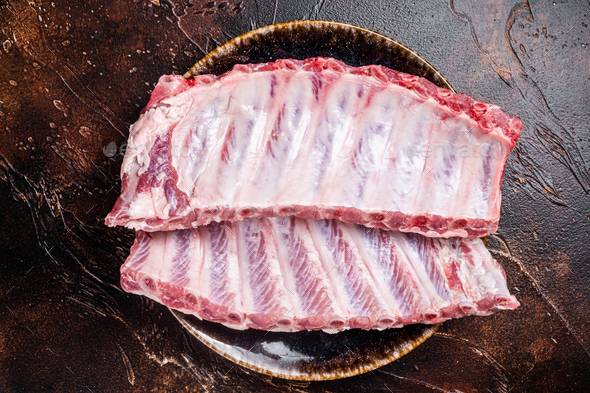 Raw Pork Spareribs, uncooked spare ribs on a plate. Dark background ...