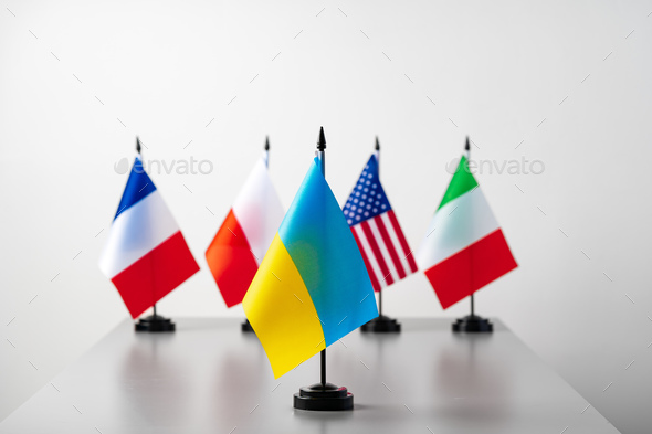 Small country flags standing at a table Stock Photo by FabrikaPhoto