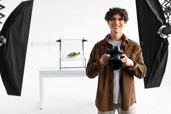 Professional european photographer man holding photo camera posing ...