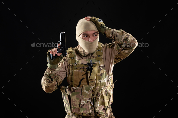 front view young soldier in uniform with gun on a black background tank ...