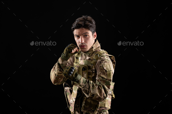 front view of military serviceman in uniform and fighter pose on black ...