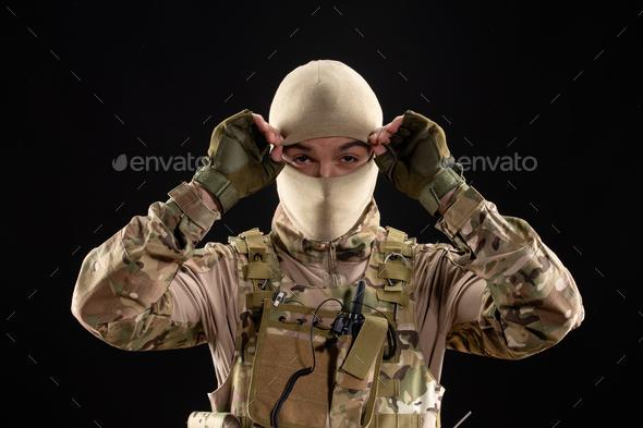 front view of young soldier in uniform on black background warrior tank ...